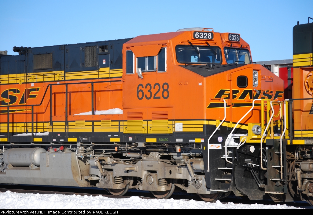 The sun finally hits the Brand new BNSF Swoosh Logo on BNSF 6328 and she awakens for another day ...